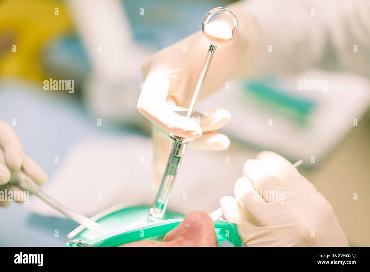 Detail of a dentist performing surgery with anesthesia on a patient for root canal treatment and ...