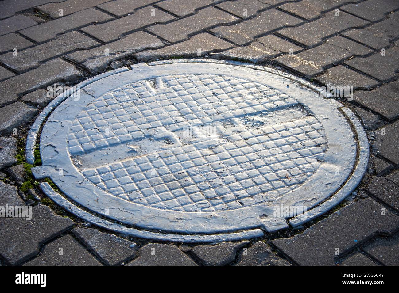 Old rusty manhole in paving slabs close up Stock Photo - Alamy