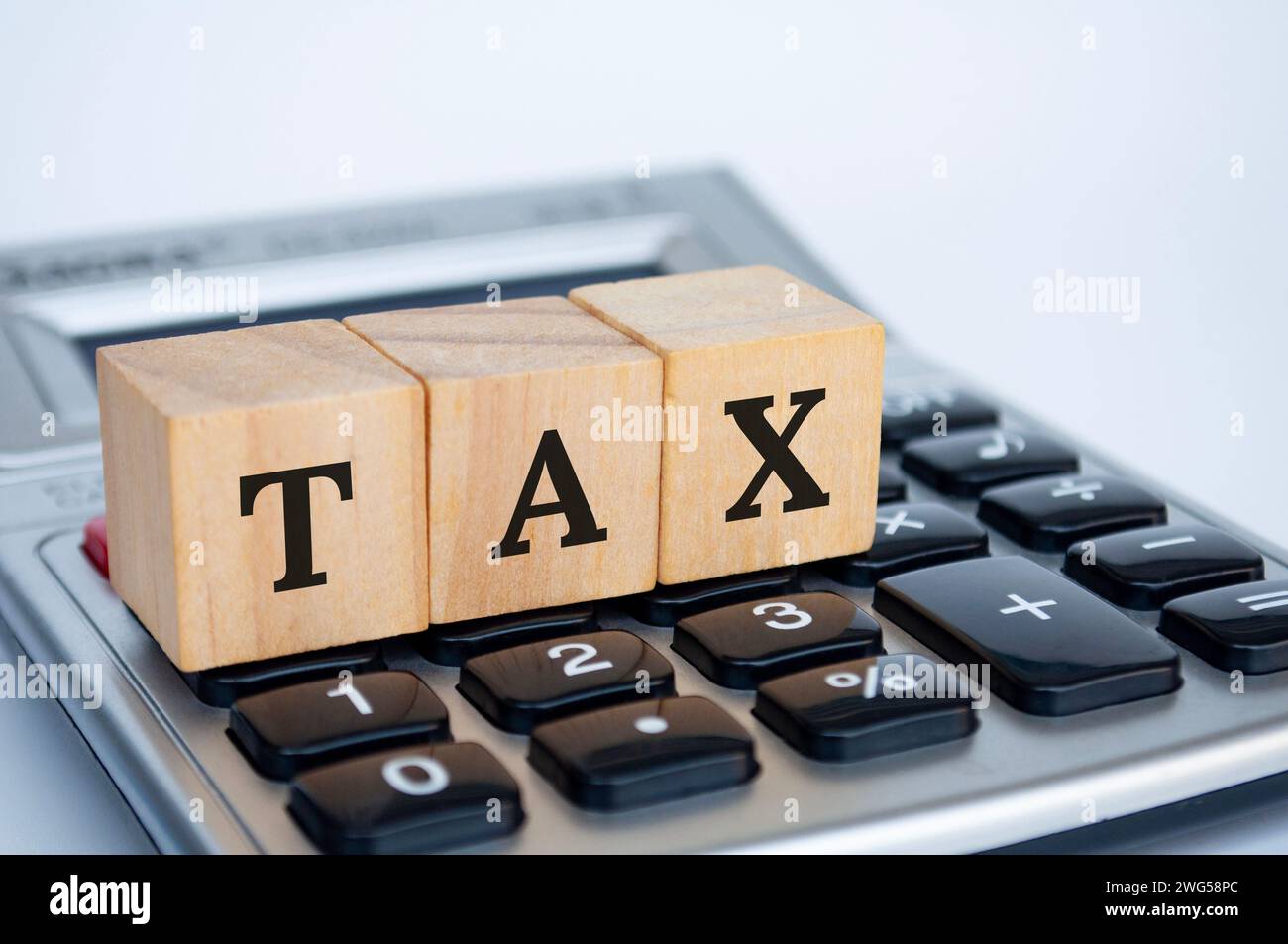 Tax word on wooden blocks on top of calculator. Tax concept Stock Photo ...
