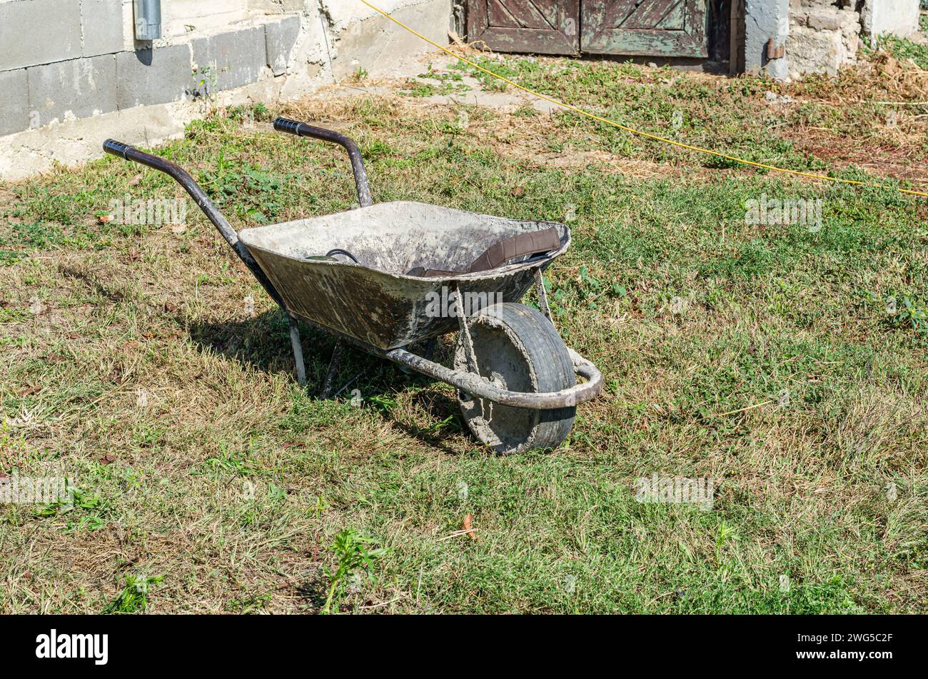 Old rusty wheelbarrow in a yard Stock Photo - Alamy