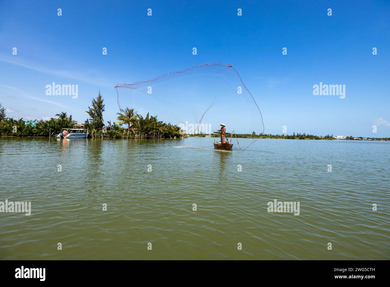 An old fisherman is throwing a net to catch fish Stock Photo - Alamy