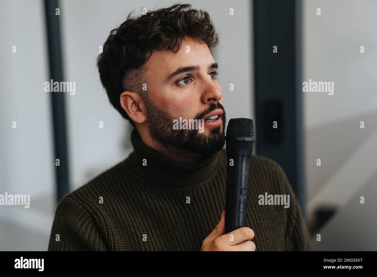 A businessman singing on a microphone during a break at the office ...