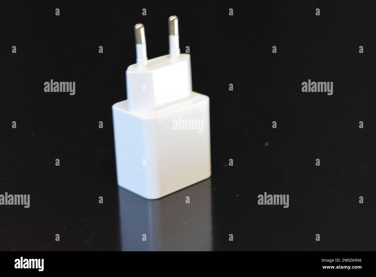 A white plug with a USB connector for charging the phone from a 220 ...