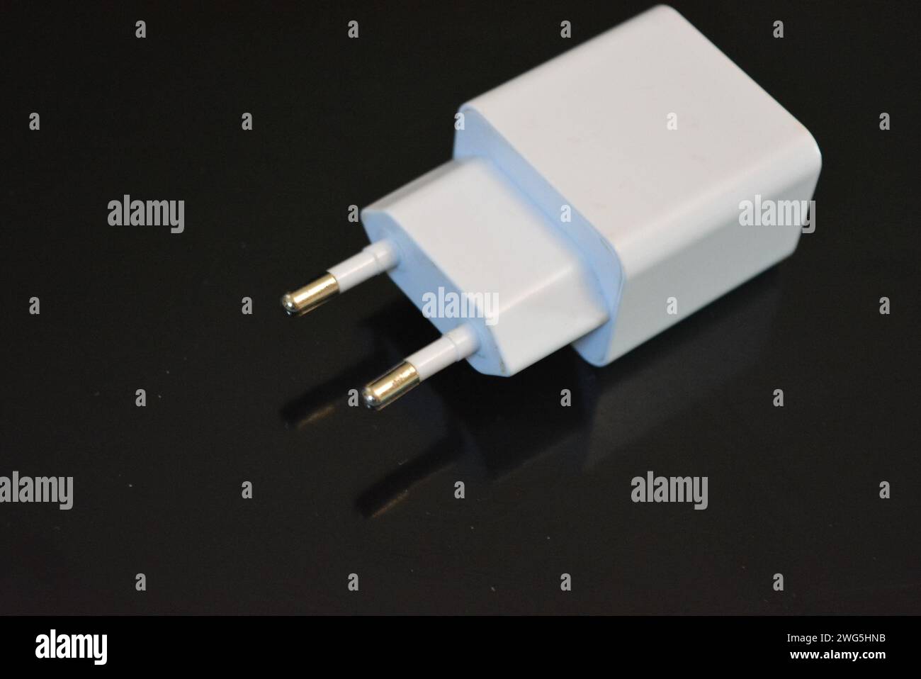 A white plug with a USB connector for charging the phone from a 220 ...