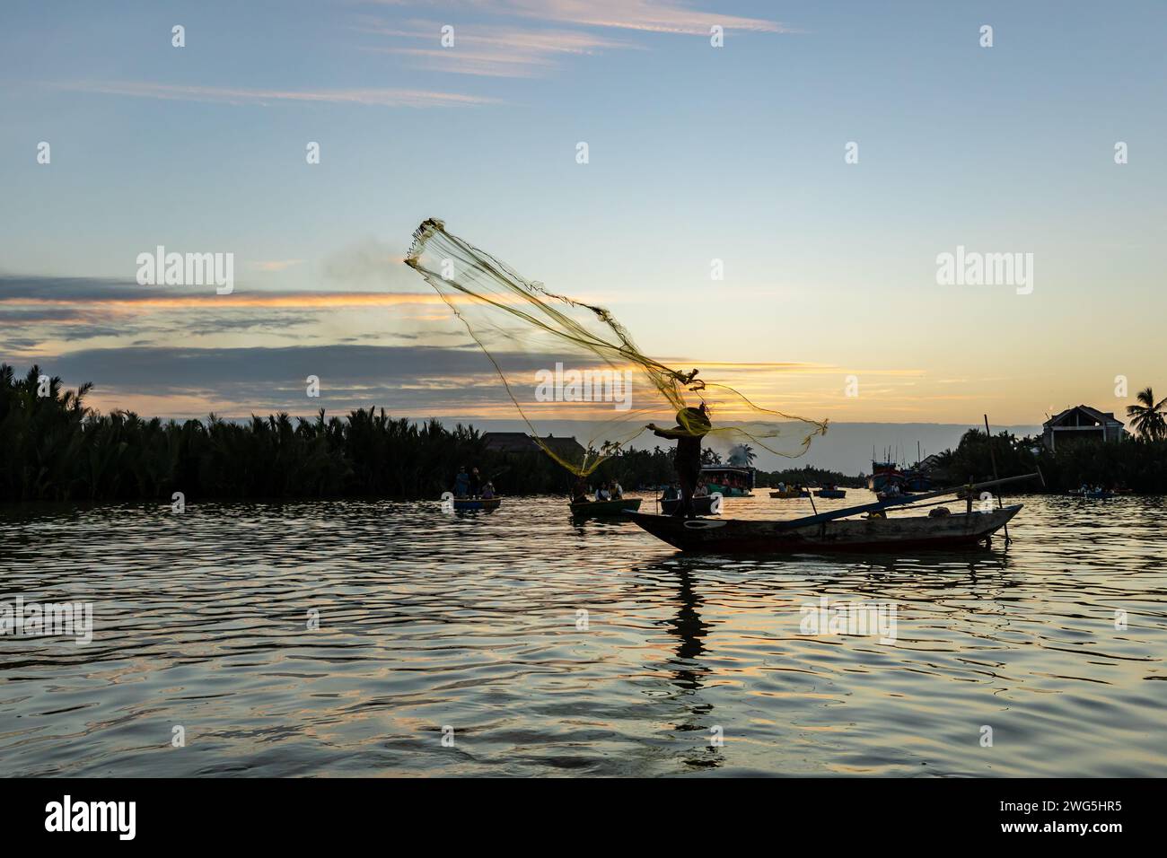 An old fisherman is throwing a net to catch fish Stock Photo - Alamy