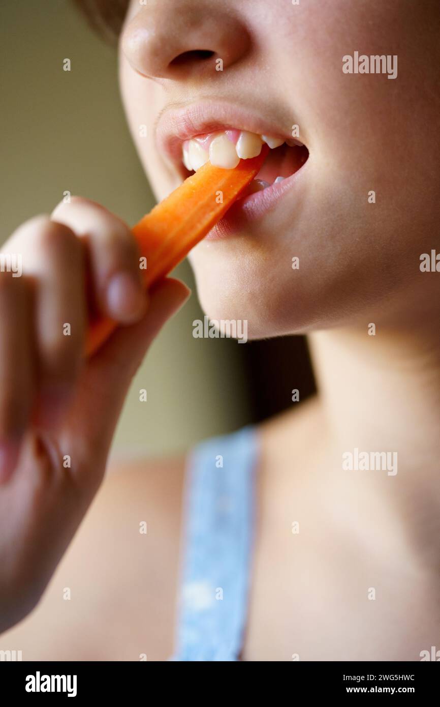 Crop anonymous girl biting organic healthy carrot slice Stock Photo - Alamy