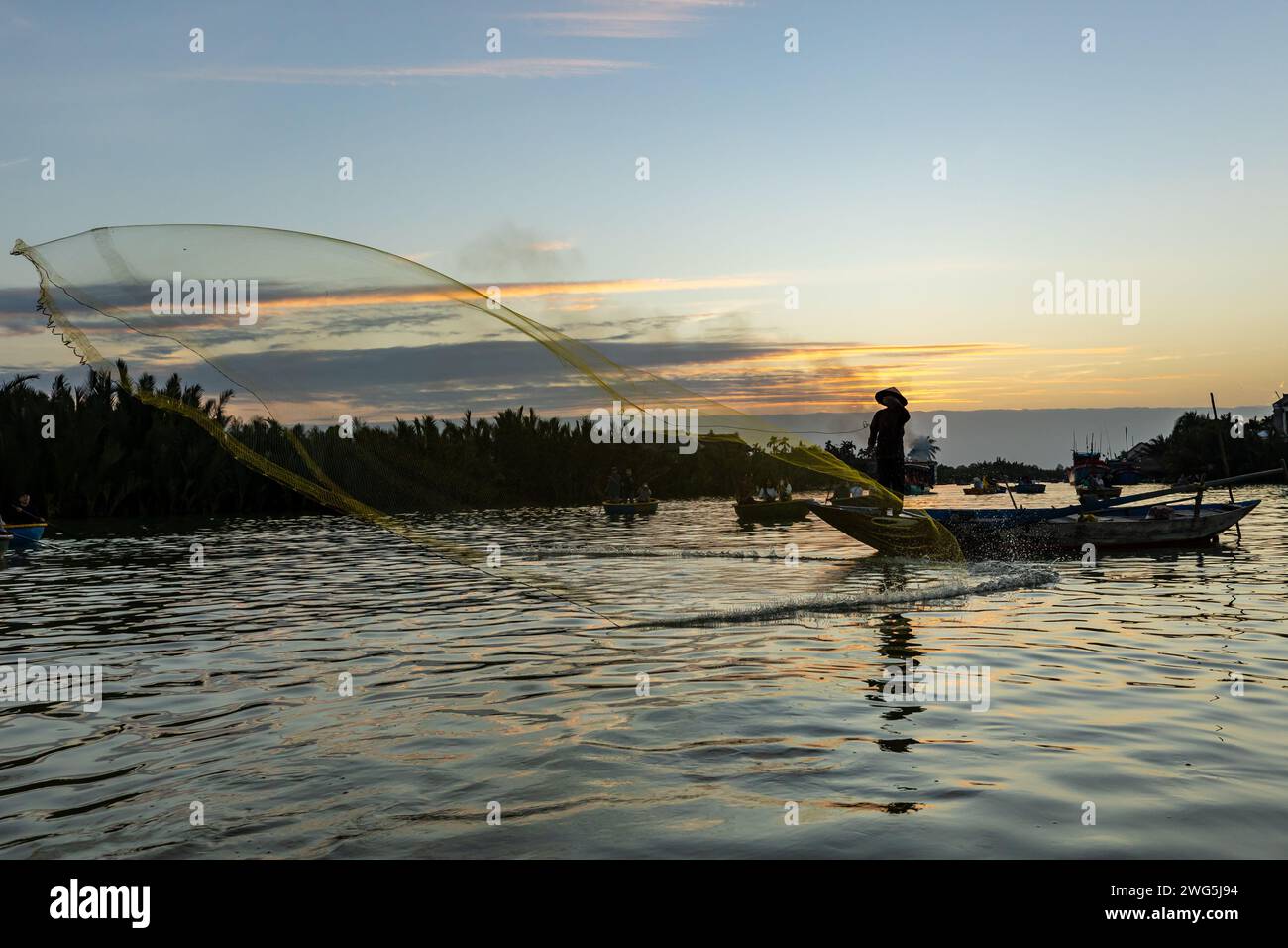 An old fisherman is throwing a net to catch fish Stock Photo - Alamy