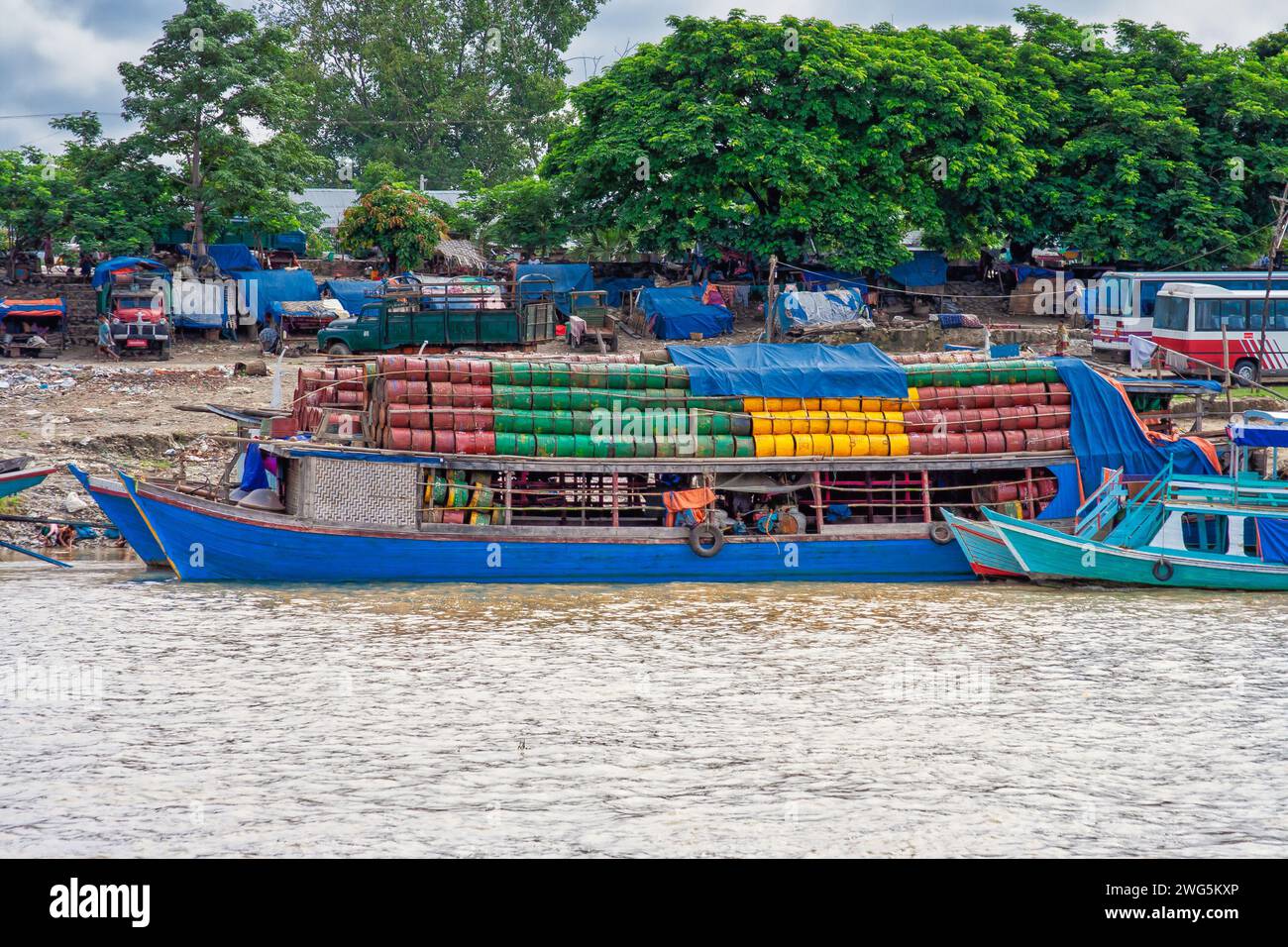 old ships loaded with colored oil barrels and a shore littered with ...