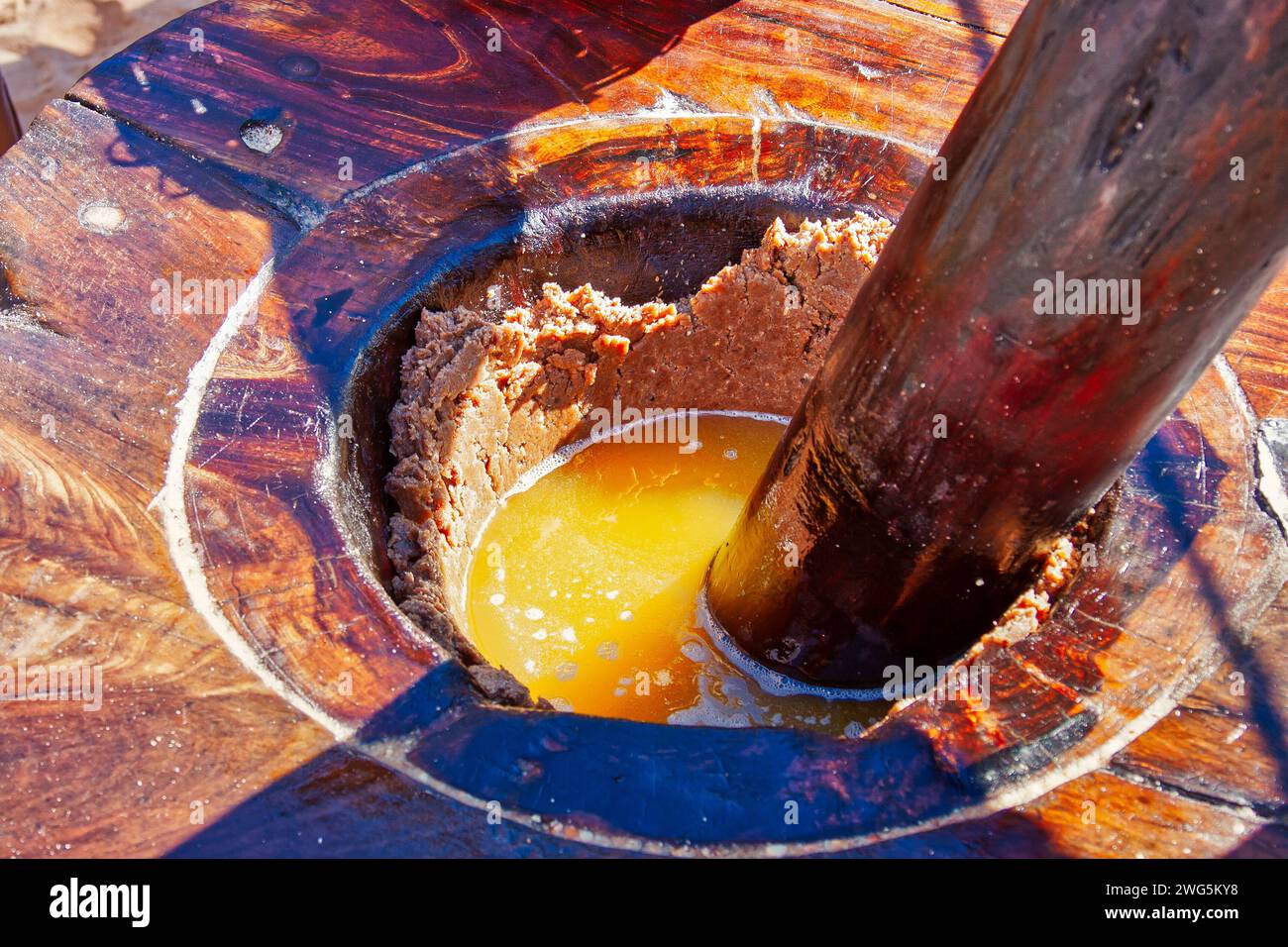 an old traditional wooden oil mill filled with golden peanut oil Stock ...