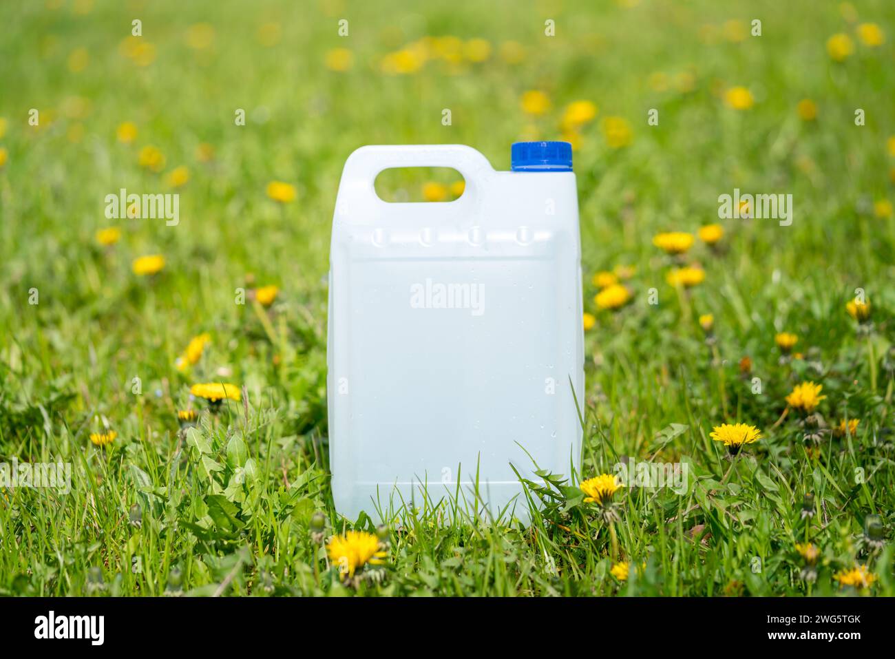 empty canister with herbicide and pesticides or fertilizers on a green ...