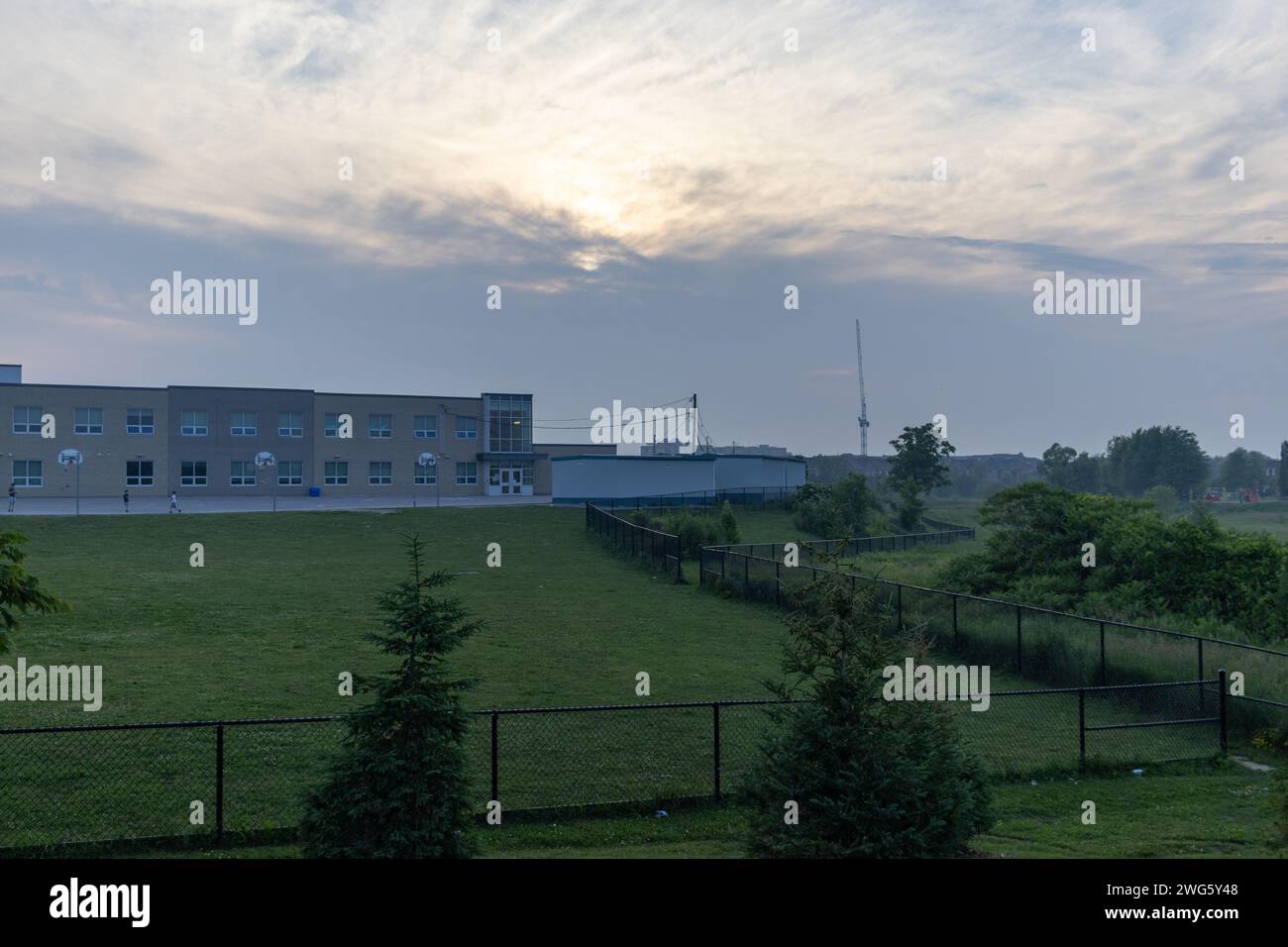 Modern school building - against a backdrop of a cloudy sky at dusk ...