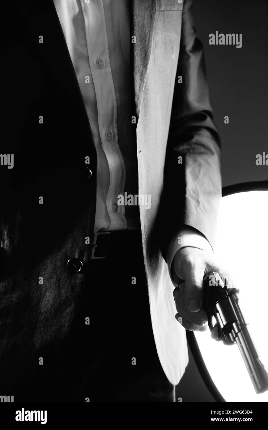 Retro secret agent with pistol revolver gun in hand in vintage crime ...