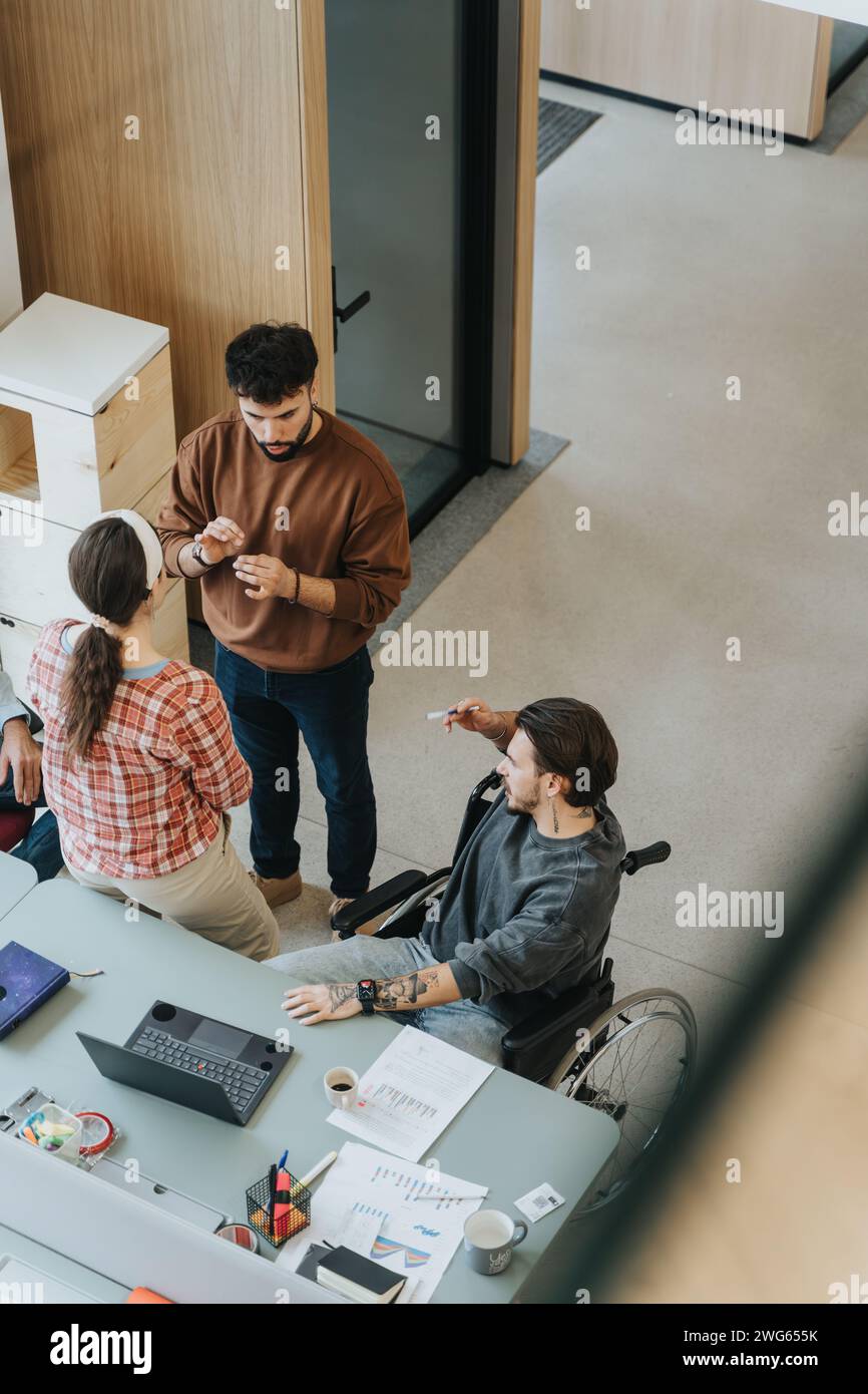 Overhead view of diverse coworkers discussing a project in an ...