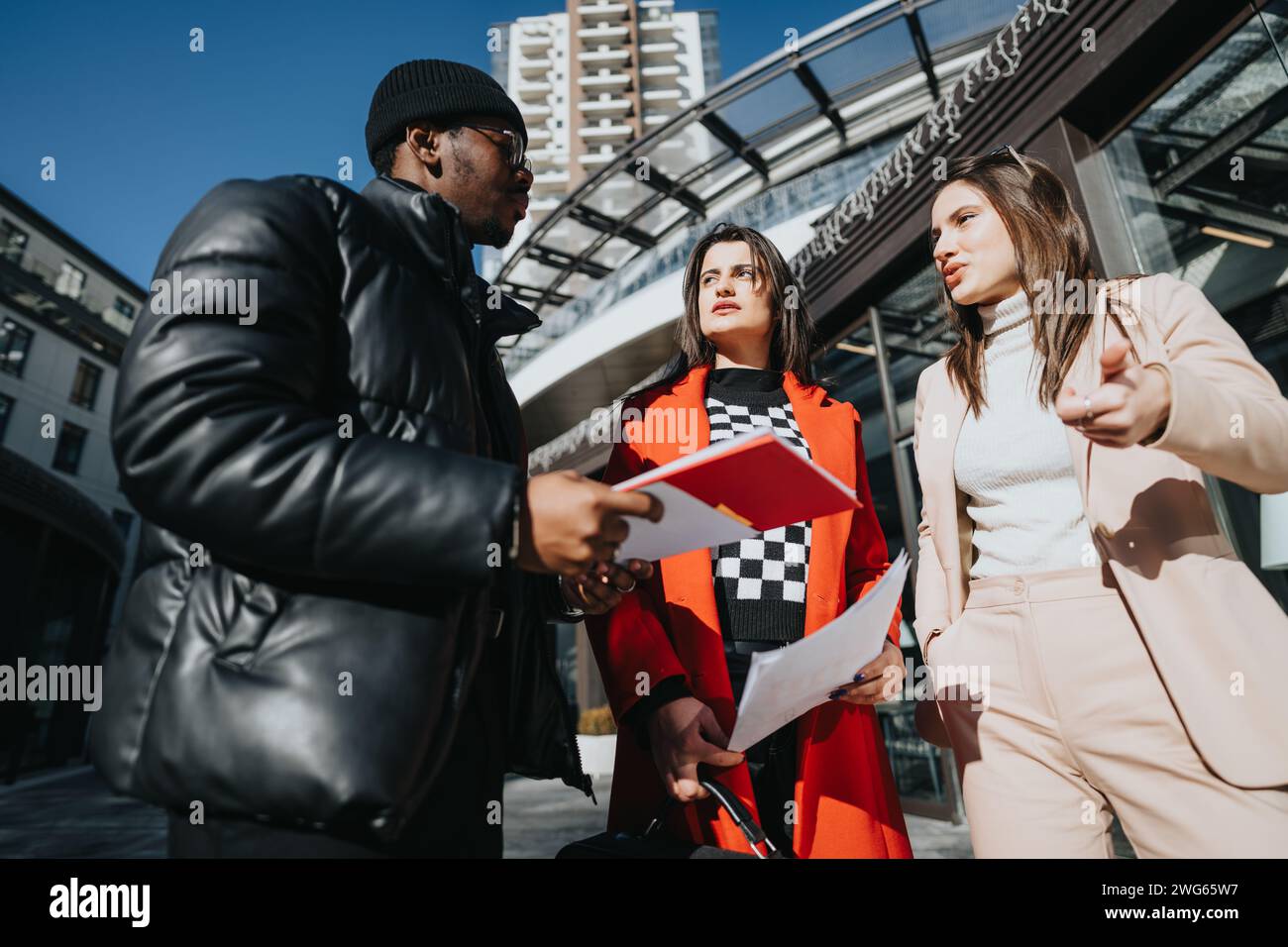 A professional man and woman engage in a friendly discussion outside an ...