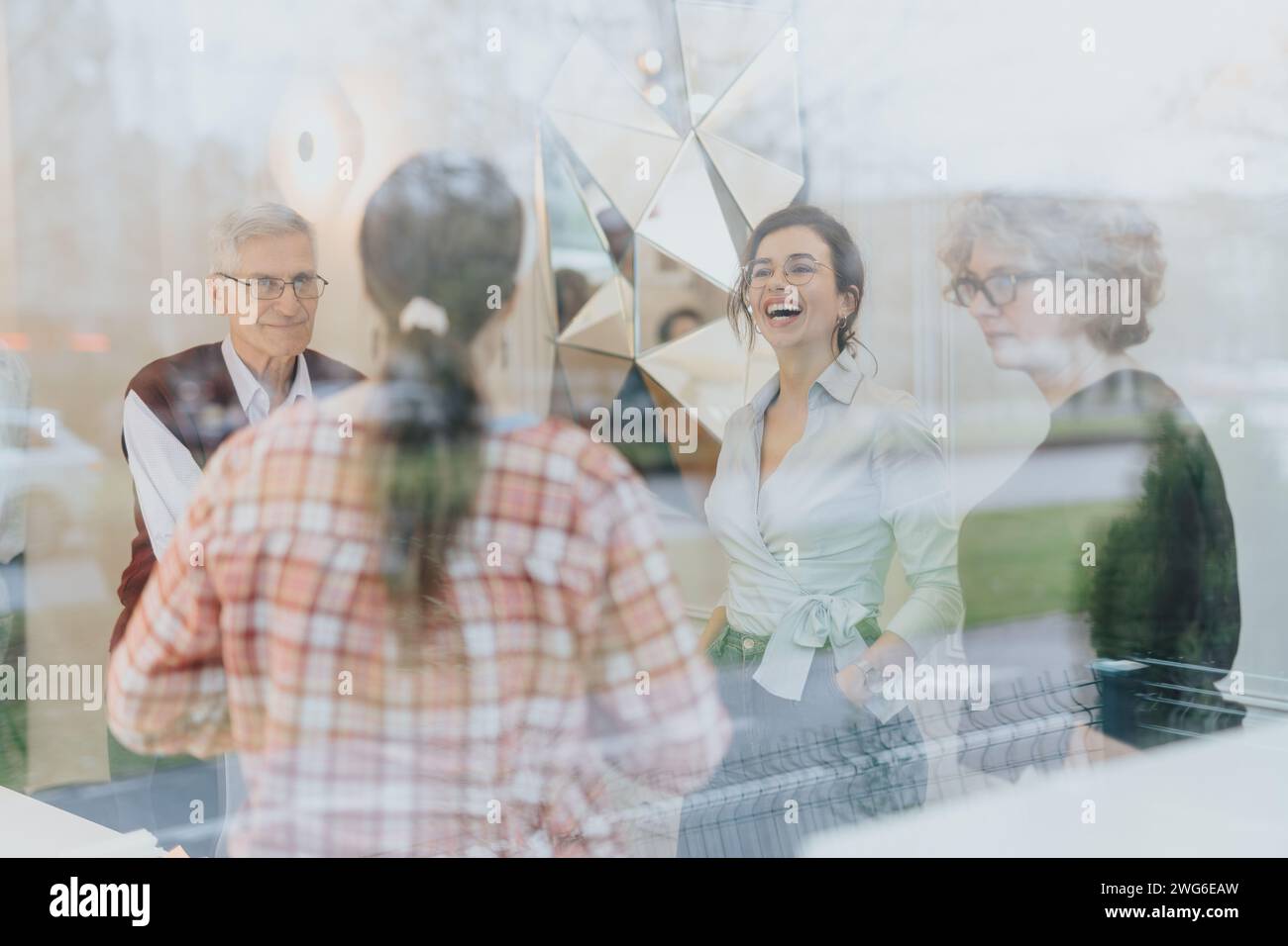 Multi generational team of coworkers discussing innovative business ...