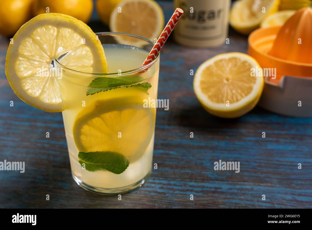 Glass of lemonade with slices and mint inside, on a rustic table with ...