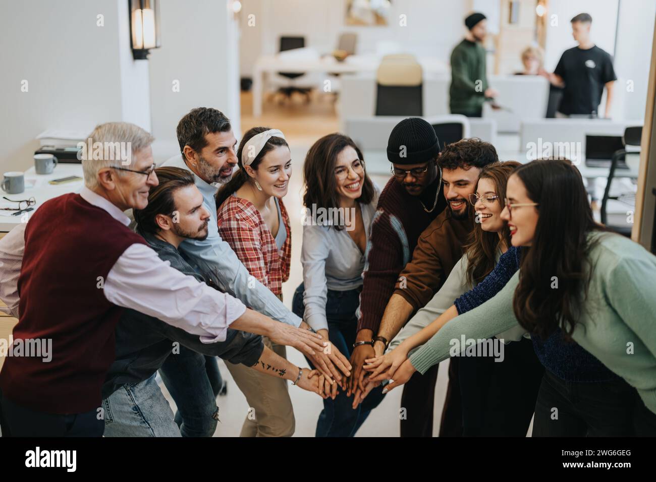 Multiracial, cross generational group of colleagues joining hands in a ...