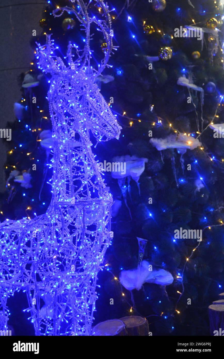 A beautiful blue diode deer and Christmas tree decorated with gold and ...