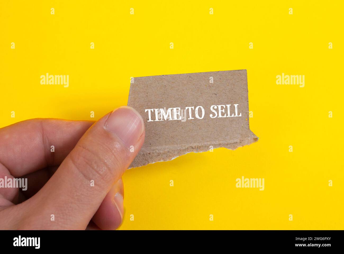 Time to sell words written on torn paper with yellow background ...