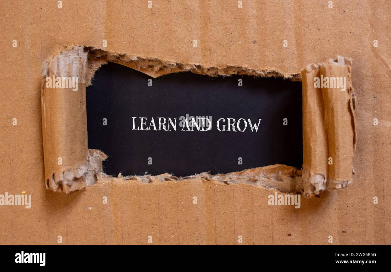 Learn and grow lettering on torn cardboard paper with black background ...