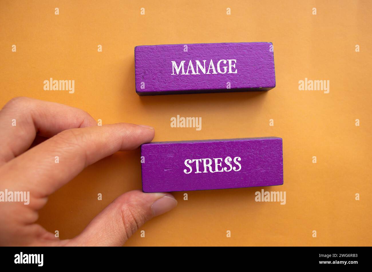Manage stress lettering on purple wooden blocks with orange background ...