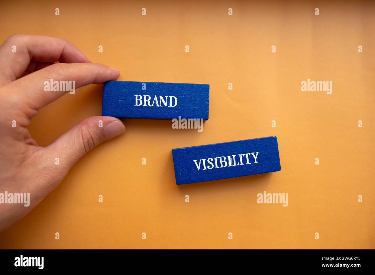 Brand visibility lettering on wooden block with orange background ...