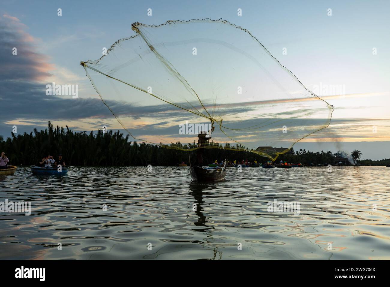 An old fisherman is throwing a net to catch fish Stock Photo - Alamy