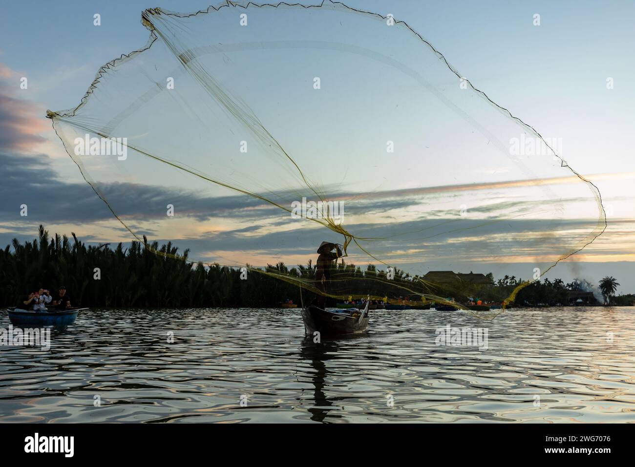 An old fisherman is throwing a net to catch fish Stock Photo - Alamy