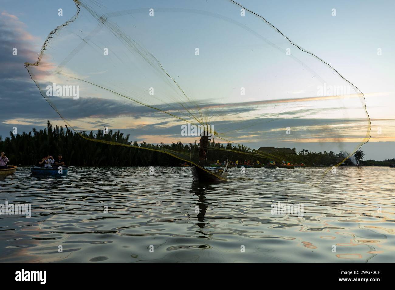 An old fisherman is throwing a net to catch fish Stock Photo - Alamy