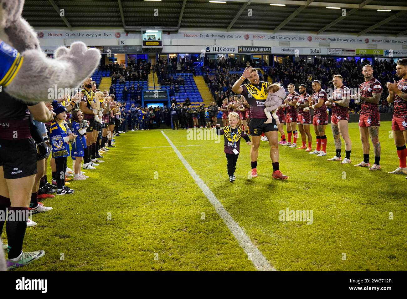 Joe Philbin of Warrington Wolves walks out with his children through a ...