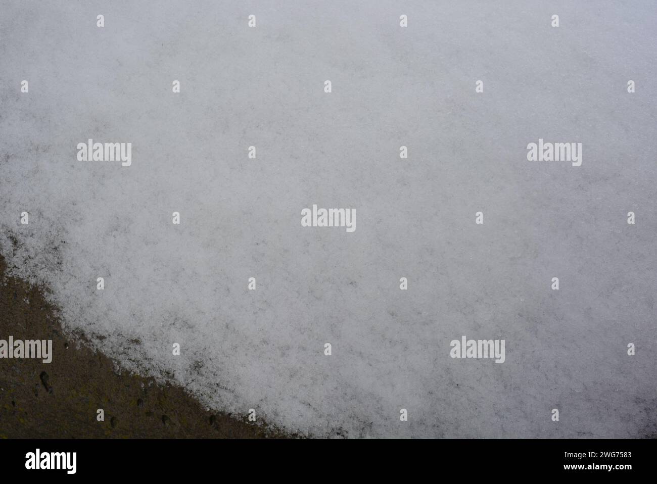 Beautiful snow background, melting snow on a concrete structure ...