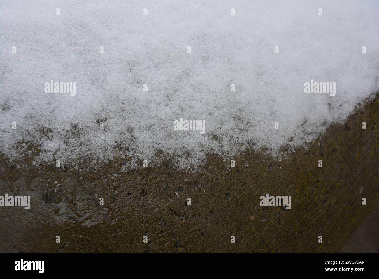 Beautiful snow background, melting snow on a concrete structure ...
