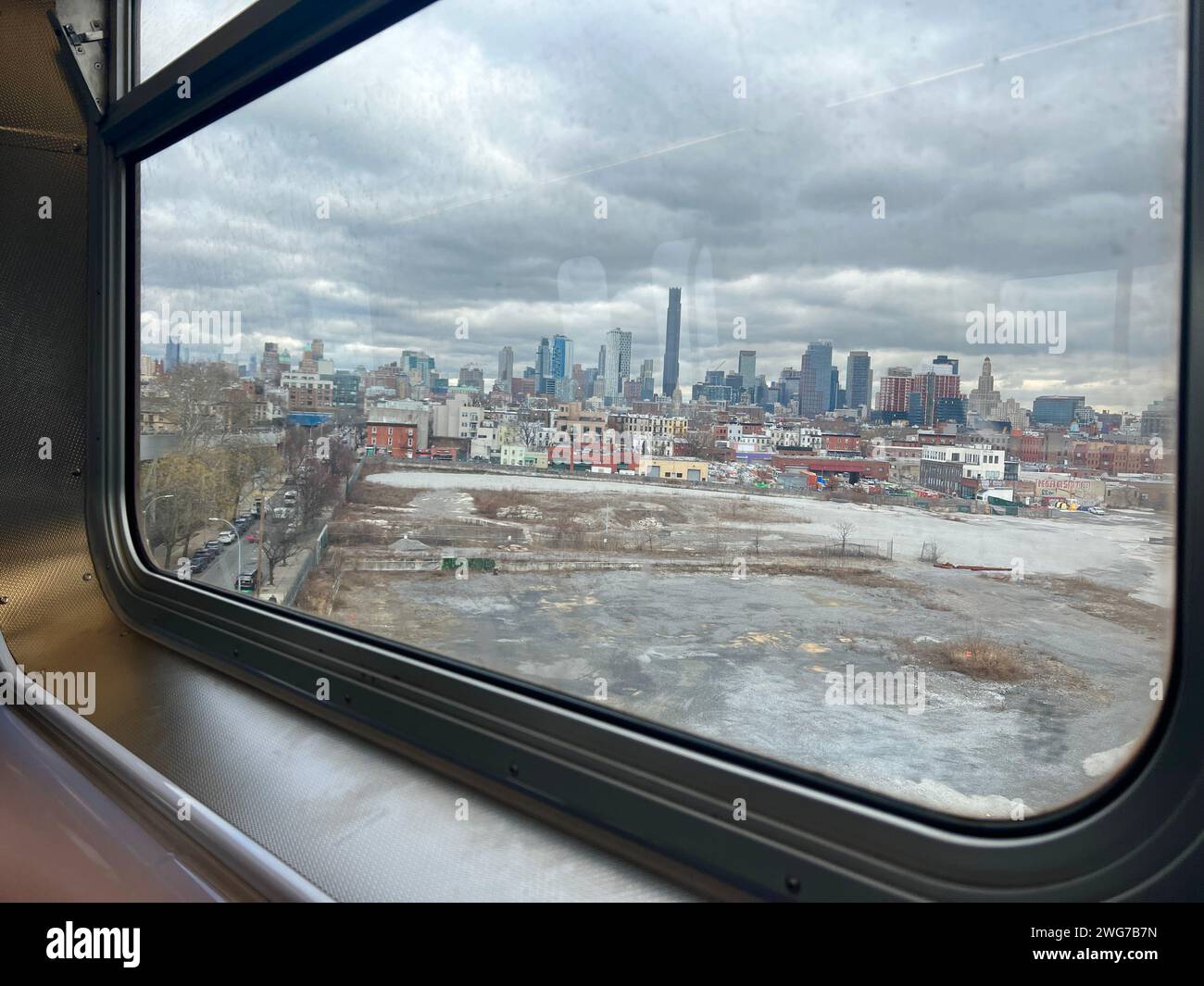View from a window on an above ground F subway train looking out across ...