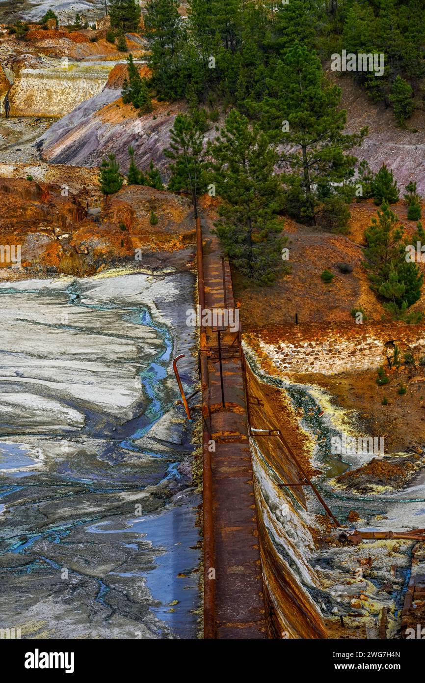 The vibrant orange hues of an acidic stream contrast with a stone wall ...