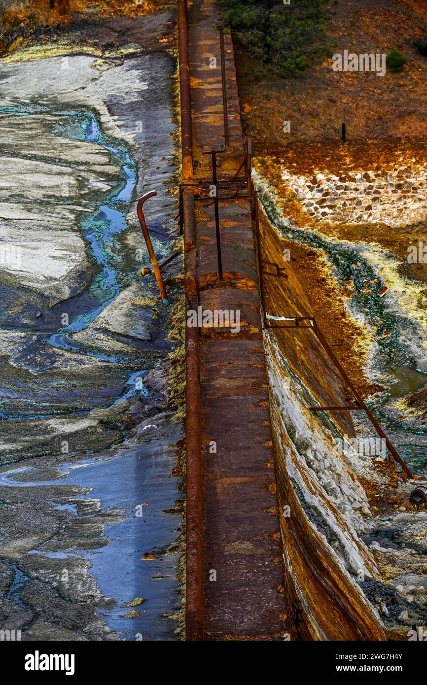 The vibrant orange hues of an acidic stream contrast with a stone wall ...