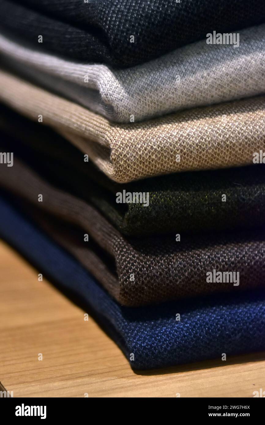 Stack of colorful clothes in a boutique. Merchendising clothing store ...