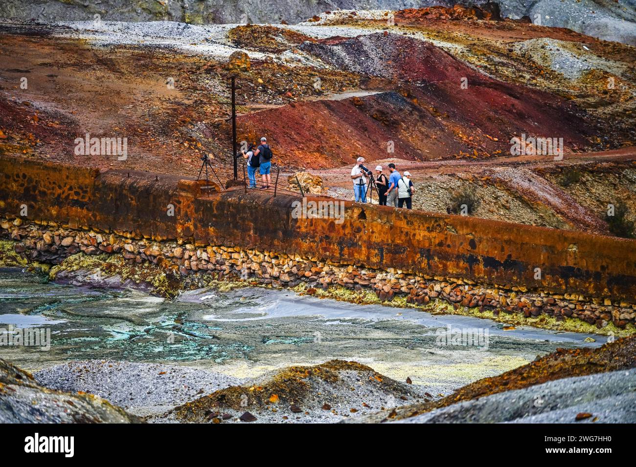 Tourists walk alongside the colorful mineral deposits and streams of ...