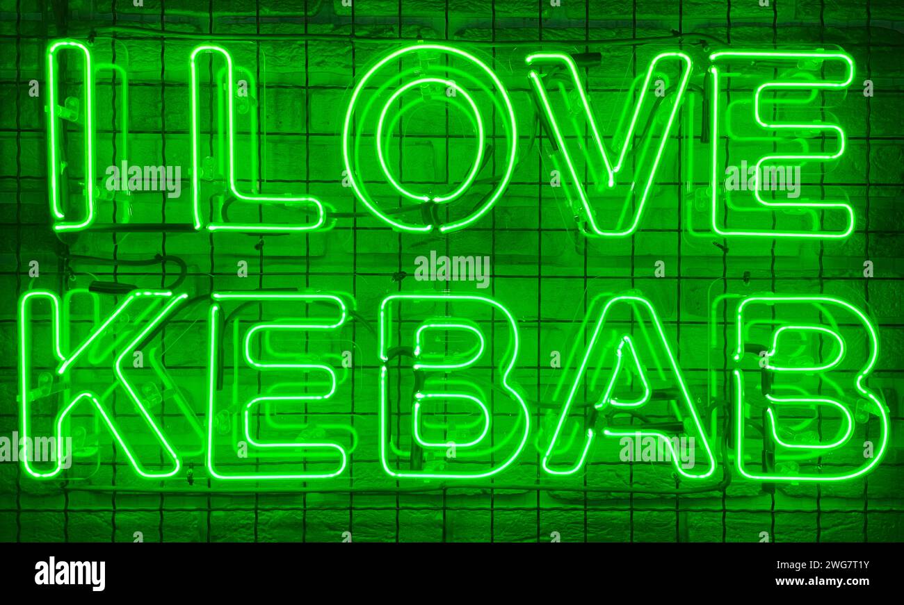 Neon shining sign in green color on a brick wall with the inscription ...