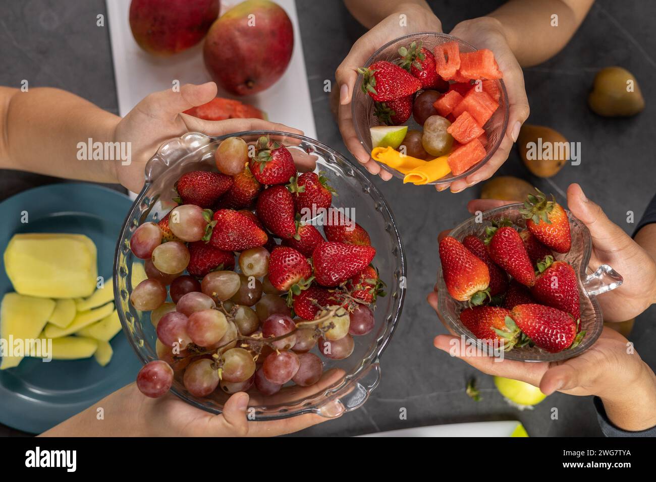 sharing fresh fruits on the table, details of strawberries, grapes ...