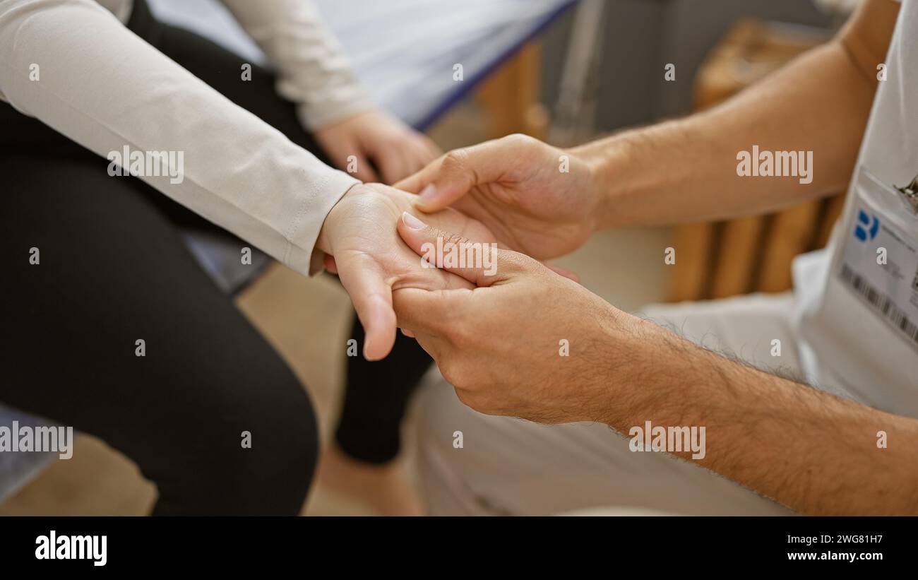 Therapist man performs hand physiotherapy on female patient in a ...