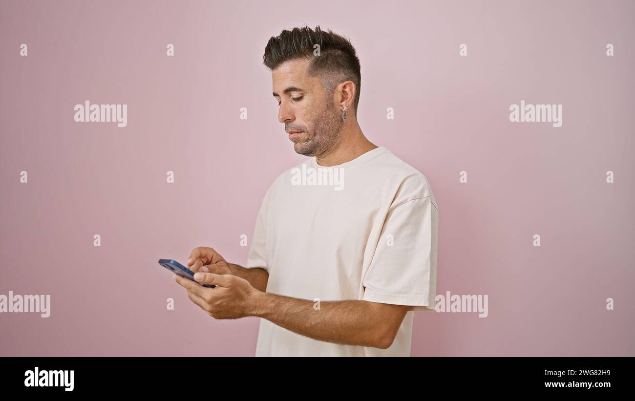 Young, serious-faced hispanic man engrossed in intense digital ...
