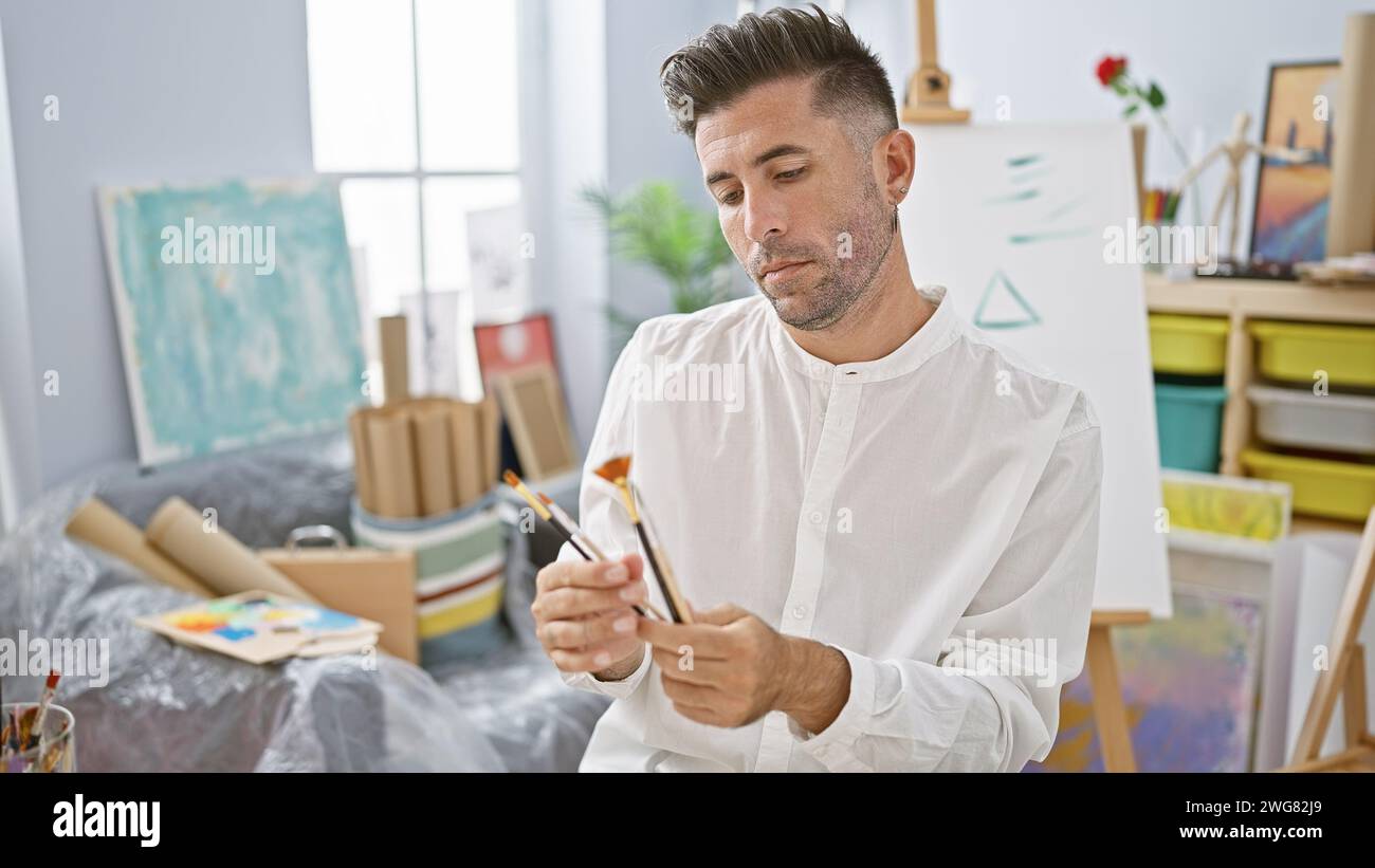 Serious-faced young hispanic man, an emerging artist, deeply engrossed ...