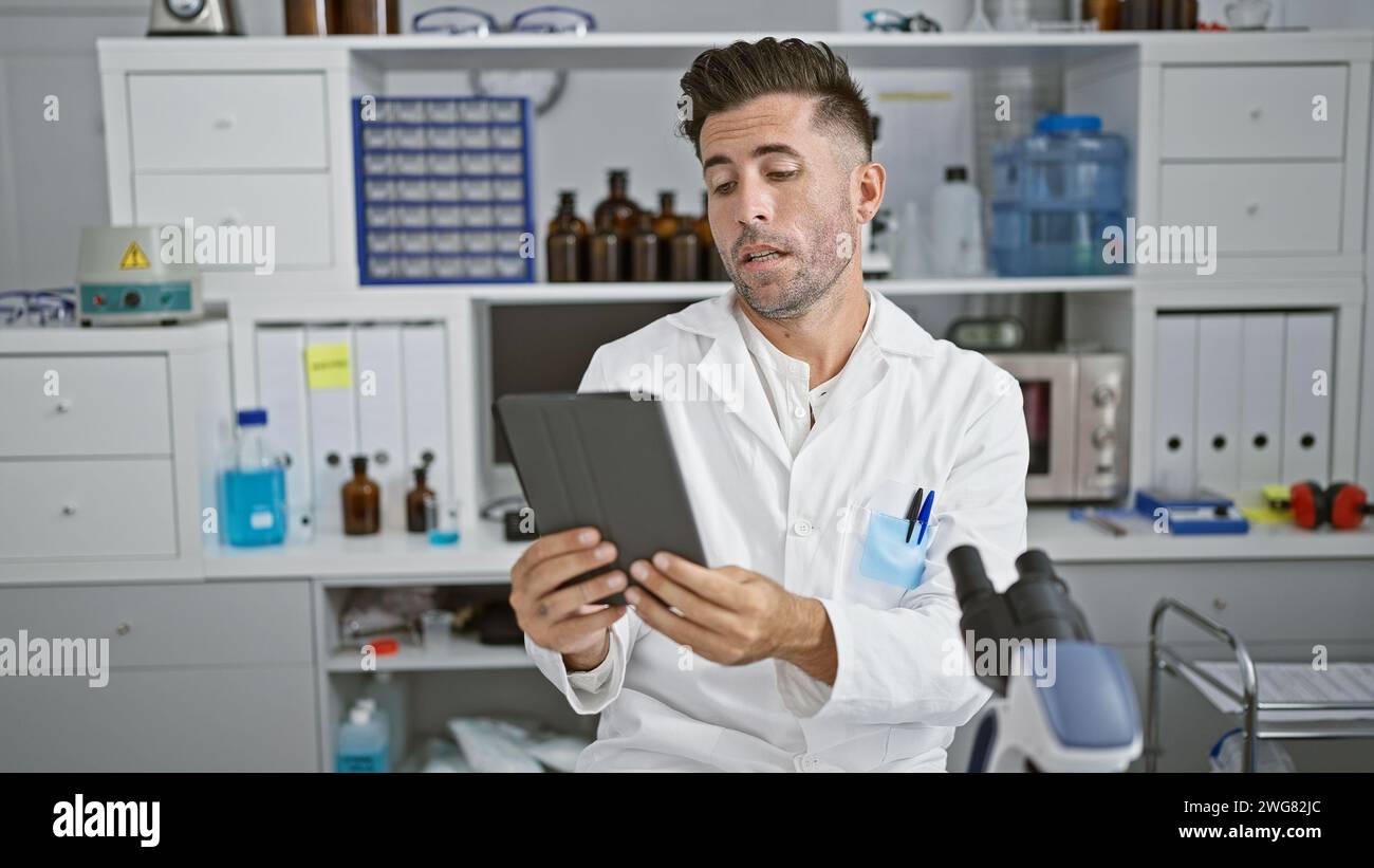 Young, attractive hispanic man, scientist, engaging in a crucial online video call conference at ...
