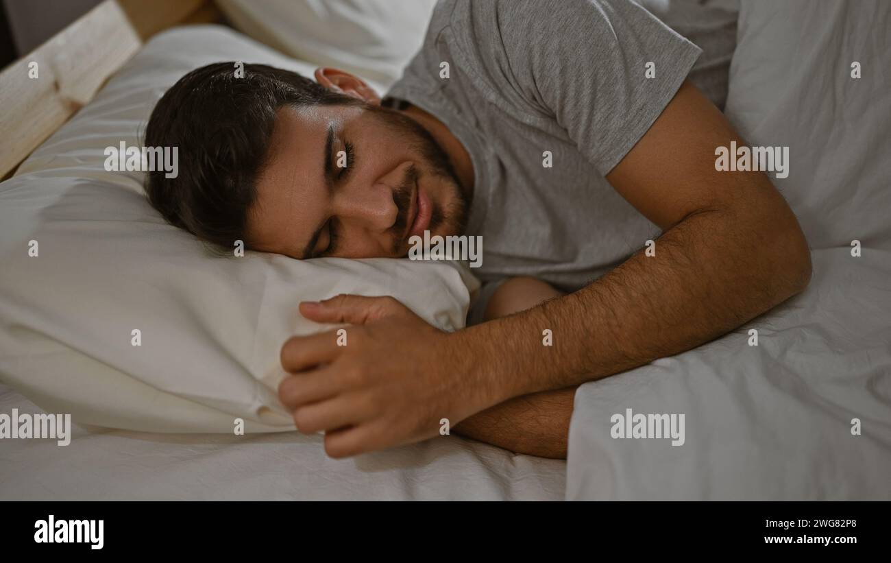 Hispanic young man sleeping peacefully in a comfortable bed indoors ...