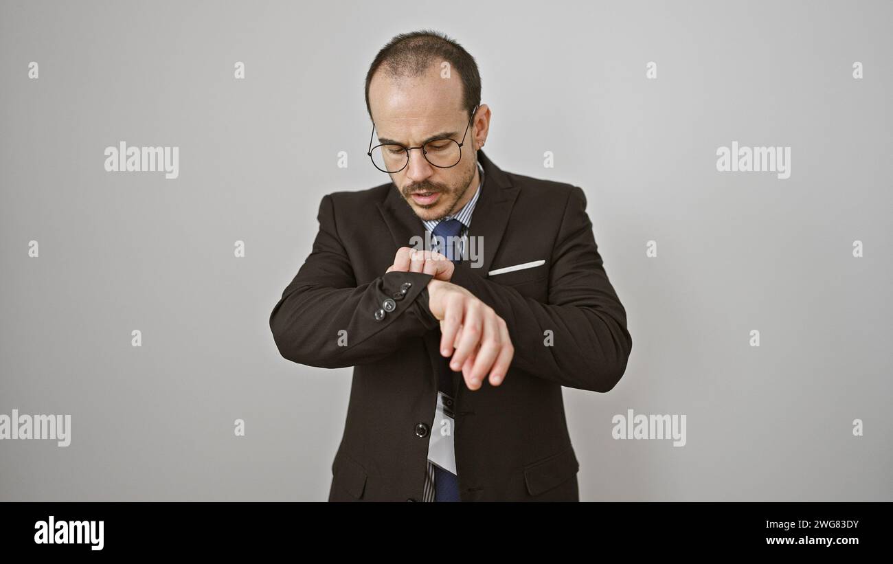 Hispanic businessman checks time on wristwatch against isolated white ...