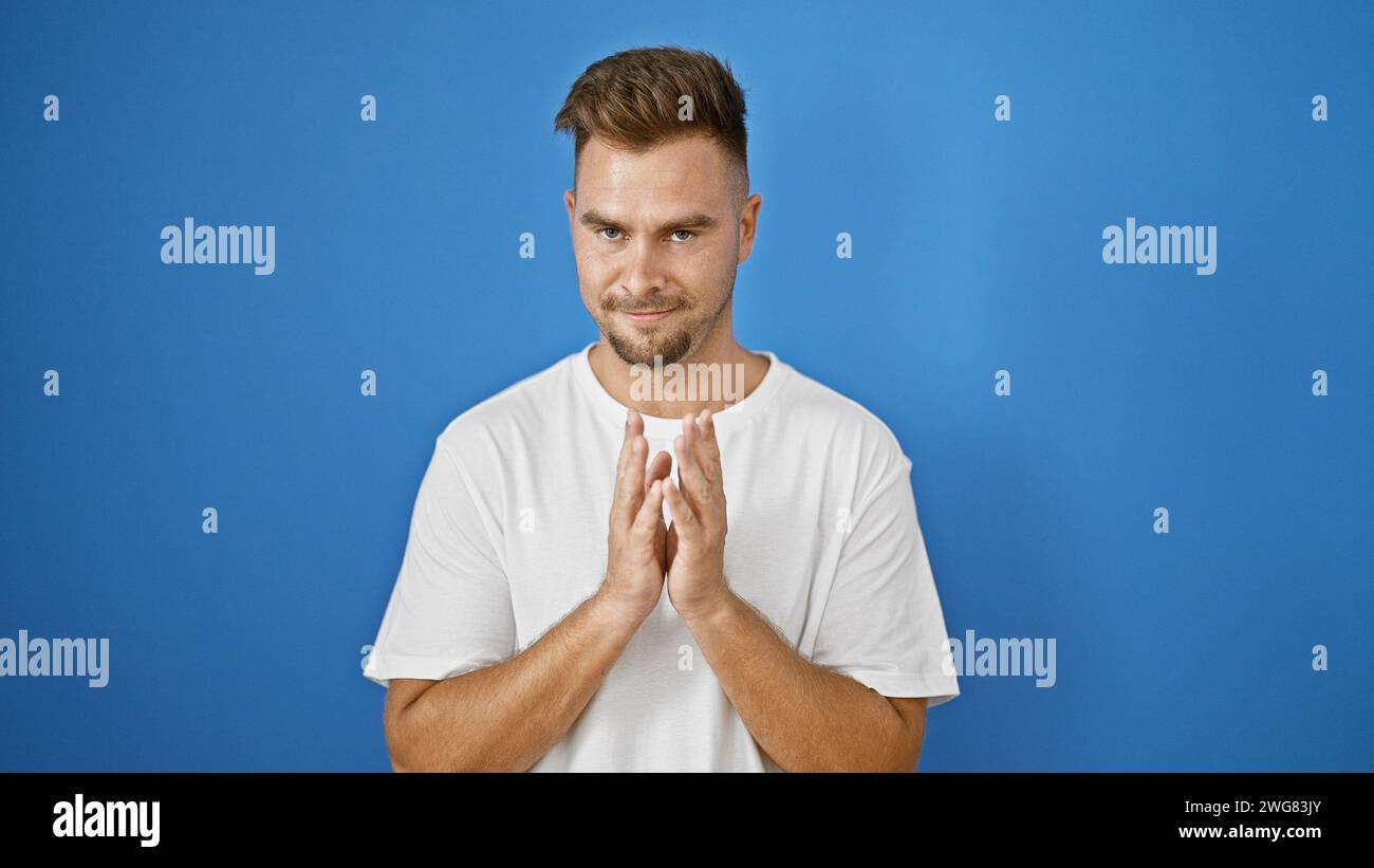 A handsome young hispanic man with a beard in a white shirt posing ...