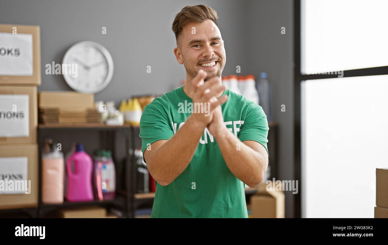 A cheerful young man clapping hands in a warehouse workplace ...