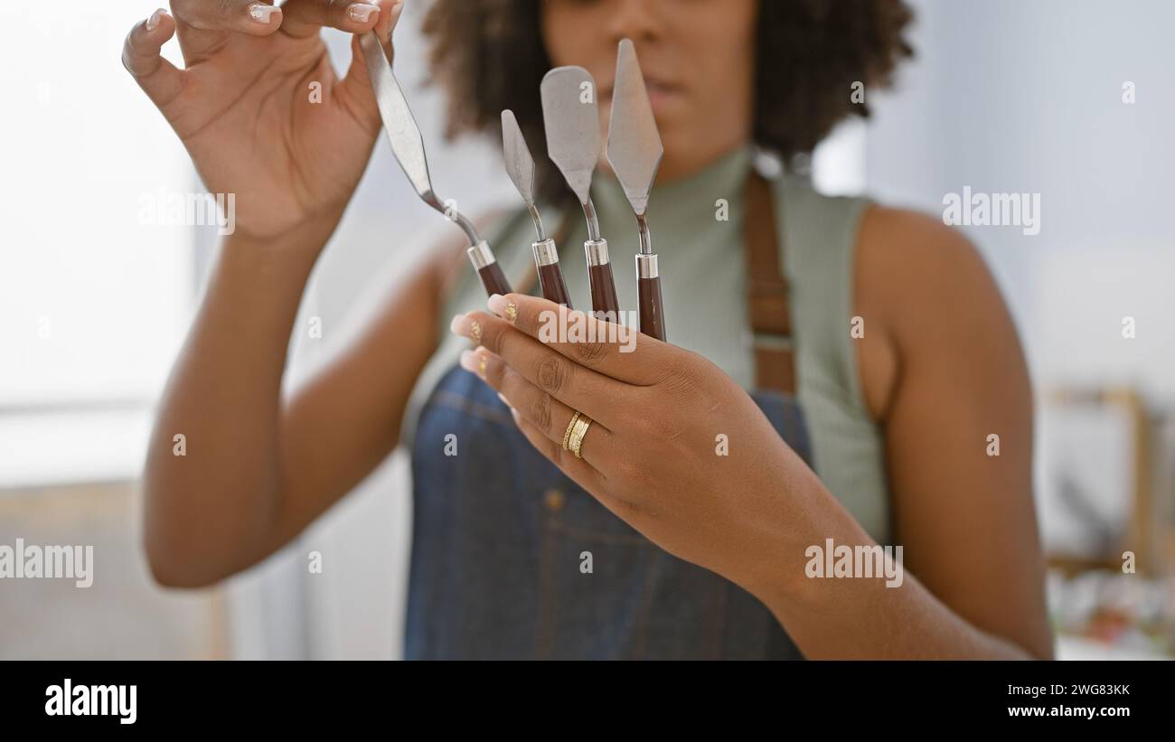 Artist examining painting tools in a studio Stock Photo - Alamy