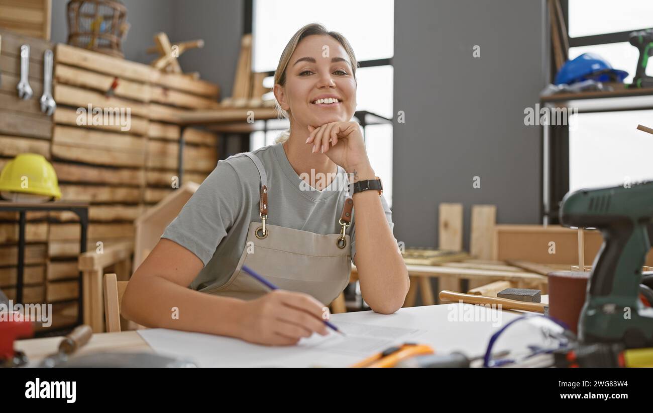 A smiling woman in a carpentry workshop sits casually with a pencil ...
