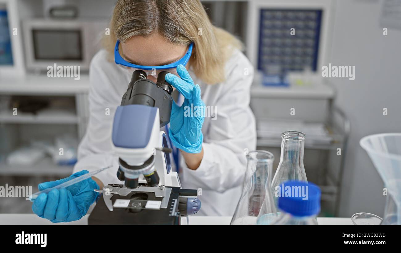Focused woman scientist uses microscope hi-res stock photography and ...
